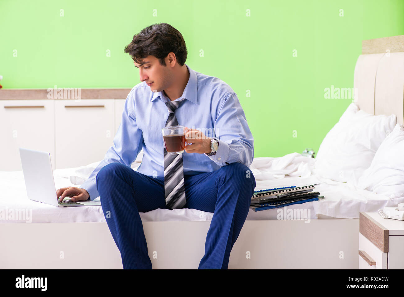 Businessman working overtime in hotel room Stock Photo - Alamy
