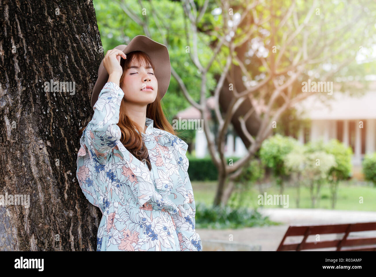 Sad woman leaning against tree hi-res stock photography and images - Alamy