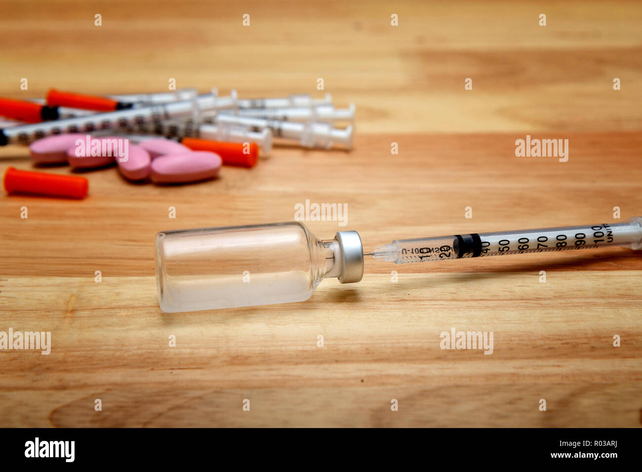 Medical syringe and bottle of potion on wooden desk Stock Photo - Alamy