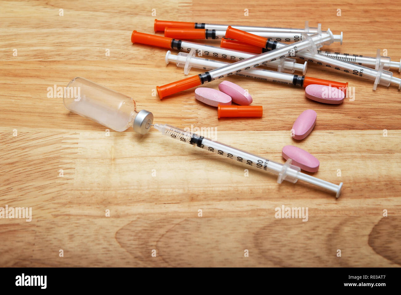 Medical syringe and bottle of potion on wooden desk Stock Photo - Alamy