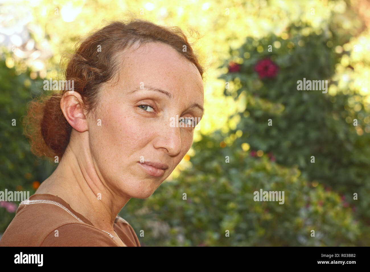Half-turn woman portrait on the flower garden background in a fine ...