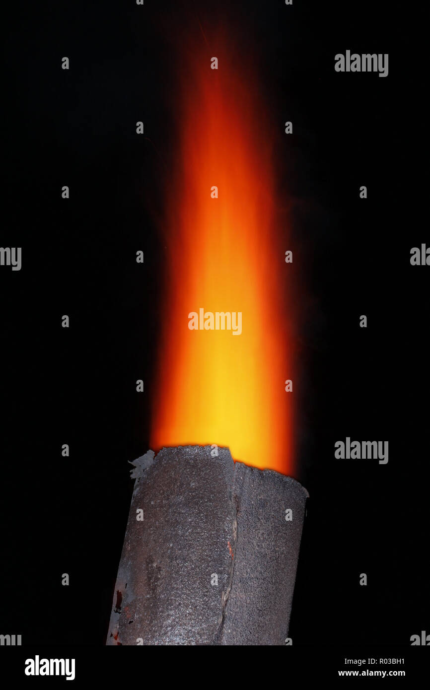 Red torch flame over the old metal chimney at night Stock Photo - Alamy