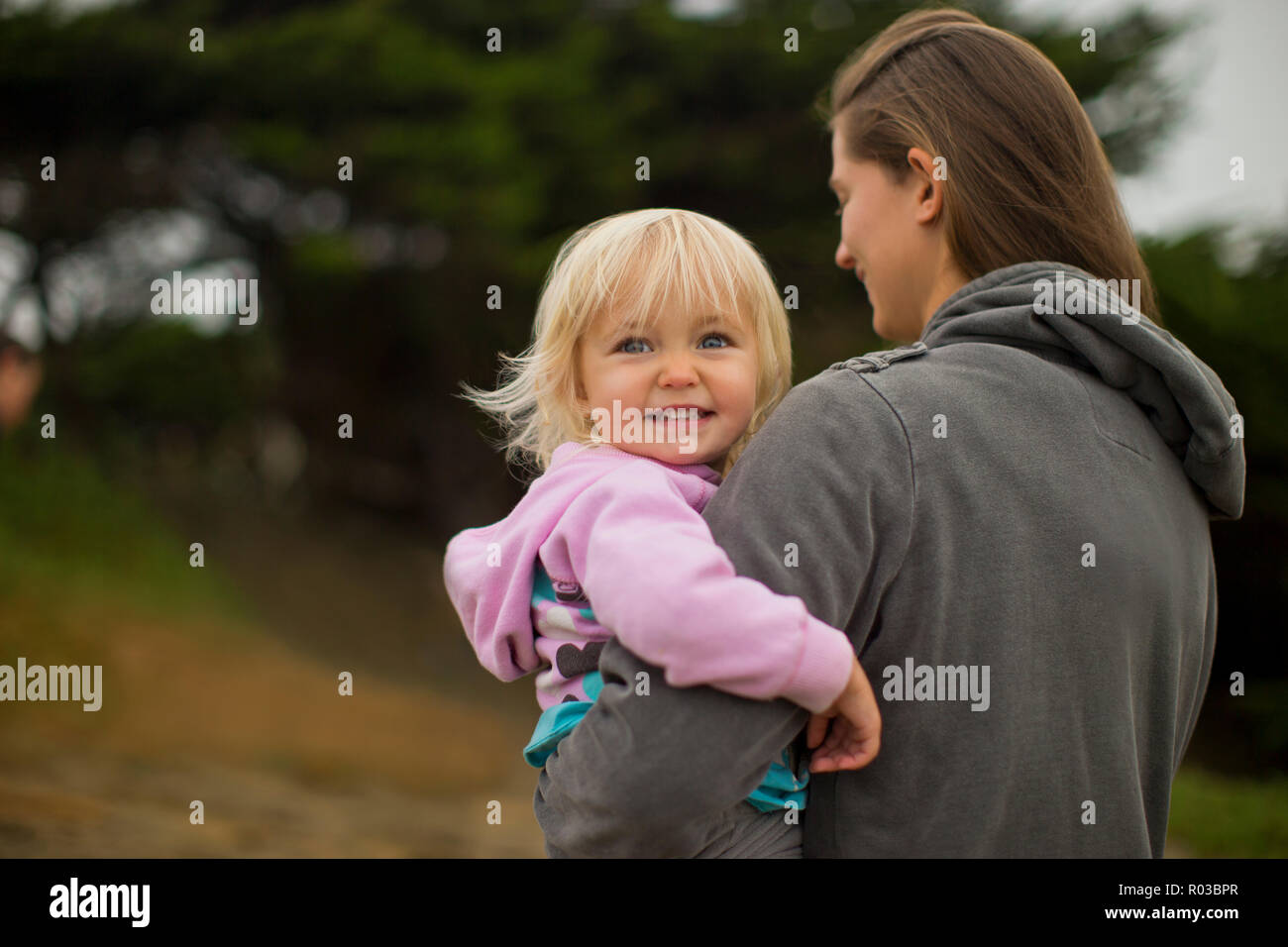 Young girl being carried by her mother Stock Photo - Alamy