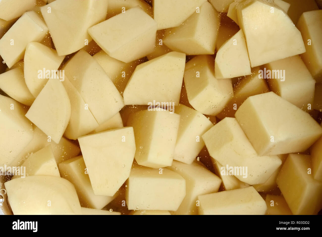 Cut into cubes potato tubers in water before cooking Stock Photo - Alamy