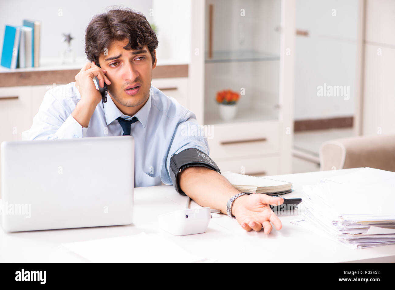 Man under stress measuring his blood pressure Stock Photo - Alamy