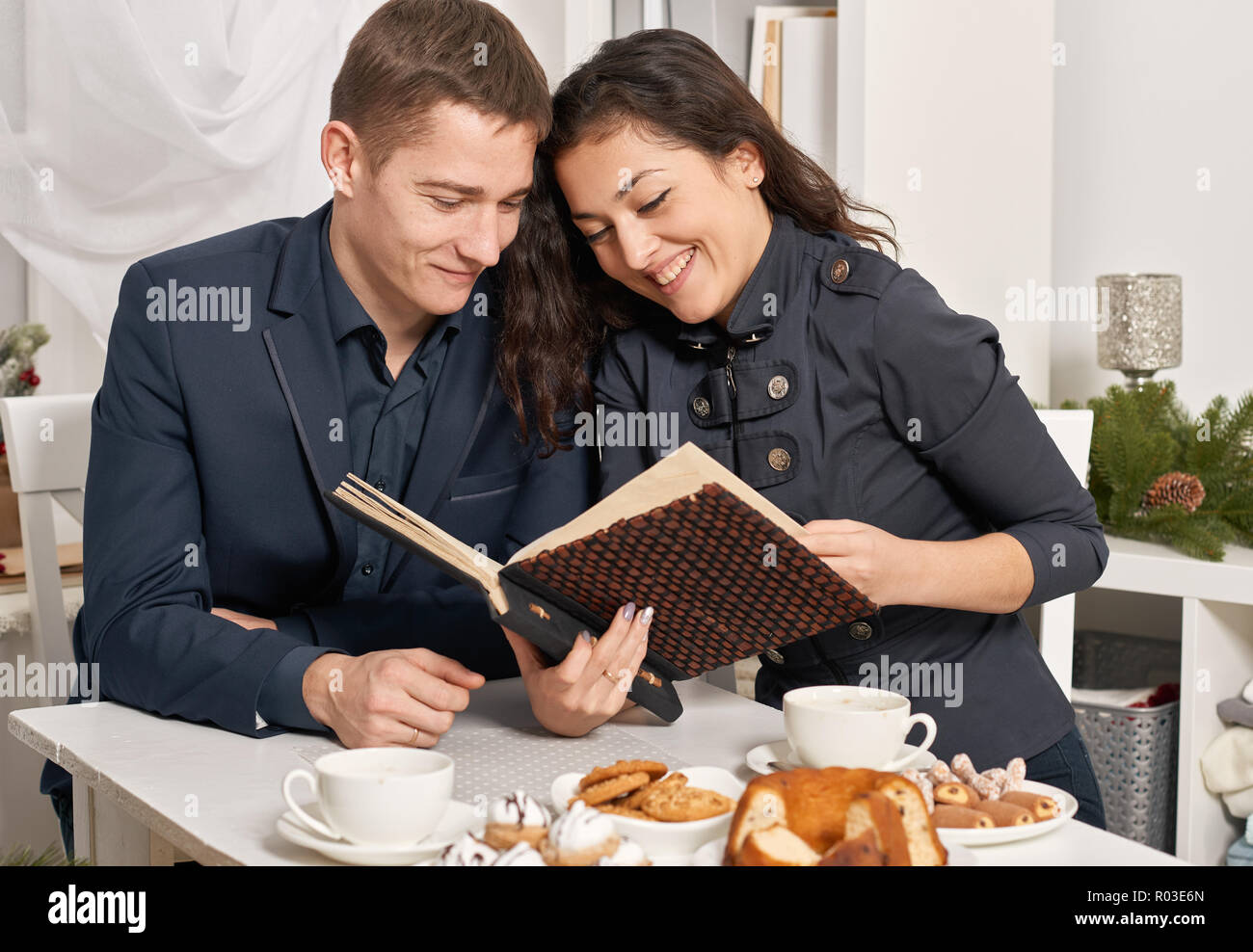 romantic couple drinking tea with cookies, talking and looking photo ...