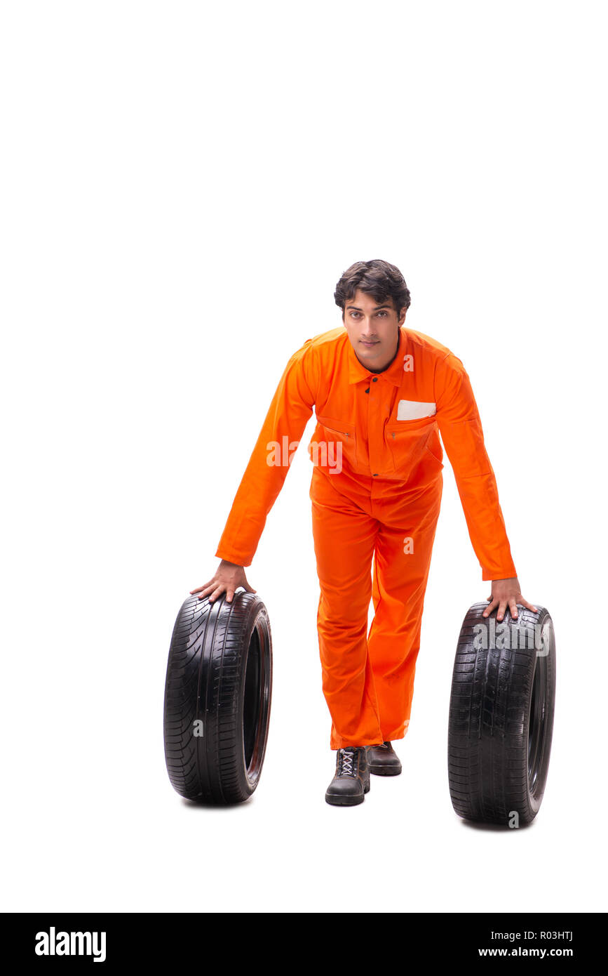 Young garage worker with tyre isolated on white Stock Photo - Alamy