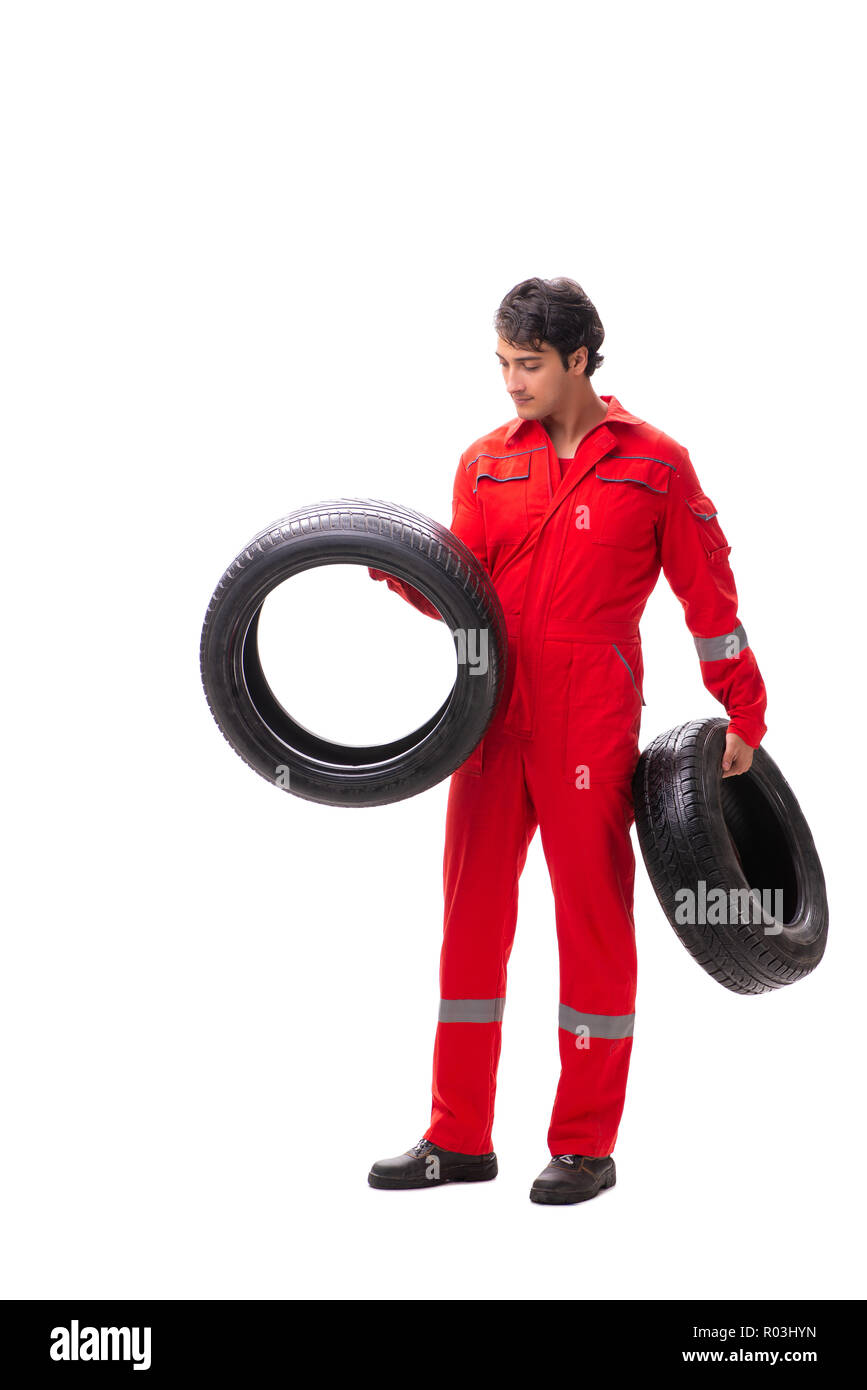 Young garage worker with tyre isolated on white Stock Photo - Alamy
