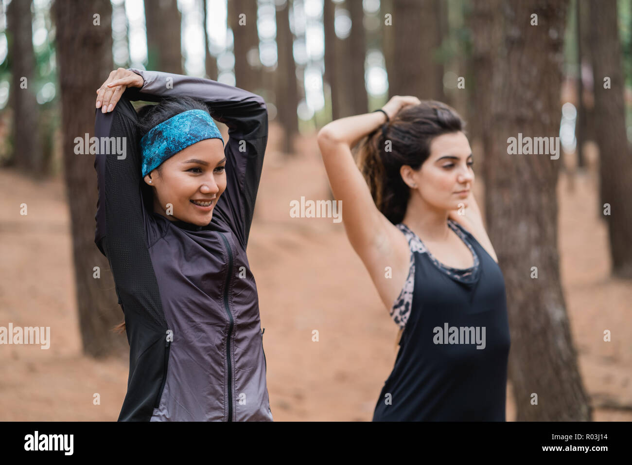 two female friend exercising in pine wood forest together Stock Photo ...