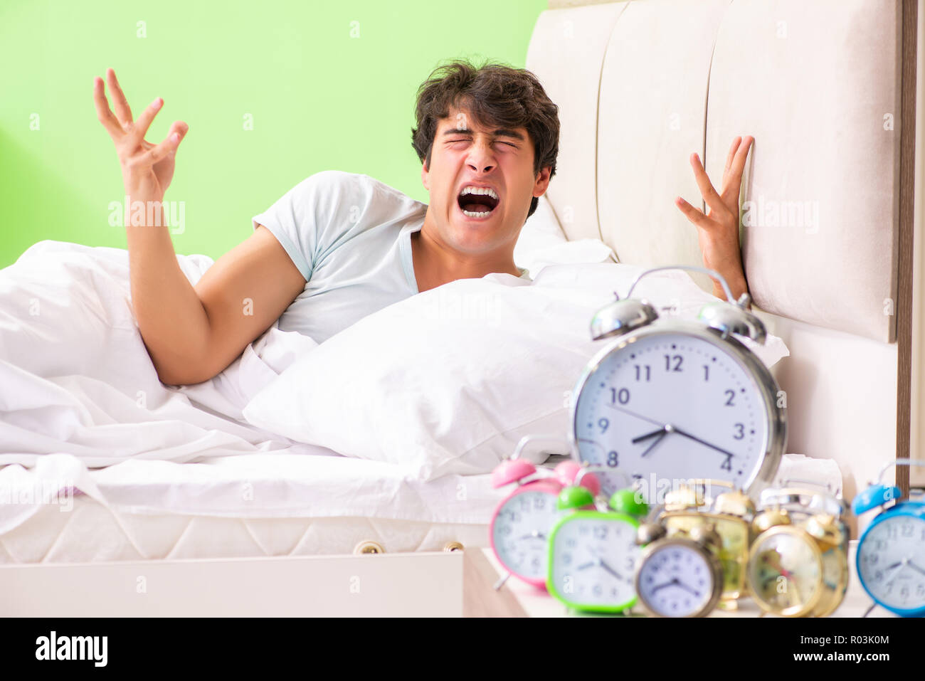 Young man having trouble waking up in early morning Stock Photo - Alamy