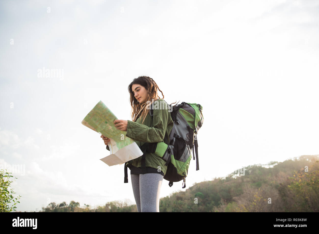 lost hiker looking at the way through map during hiking in wilderness ...