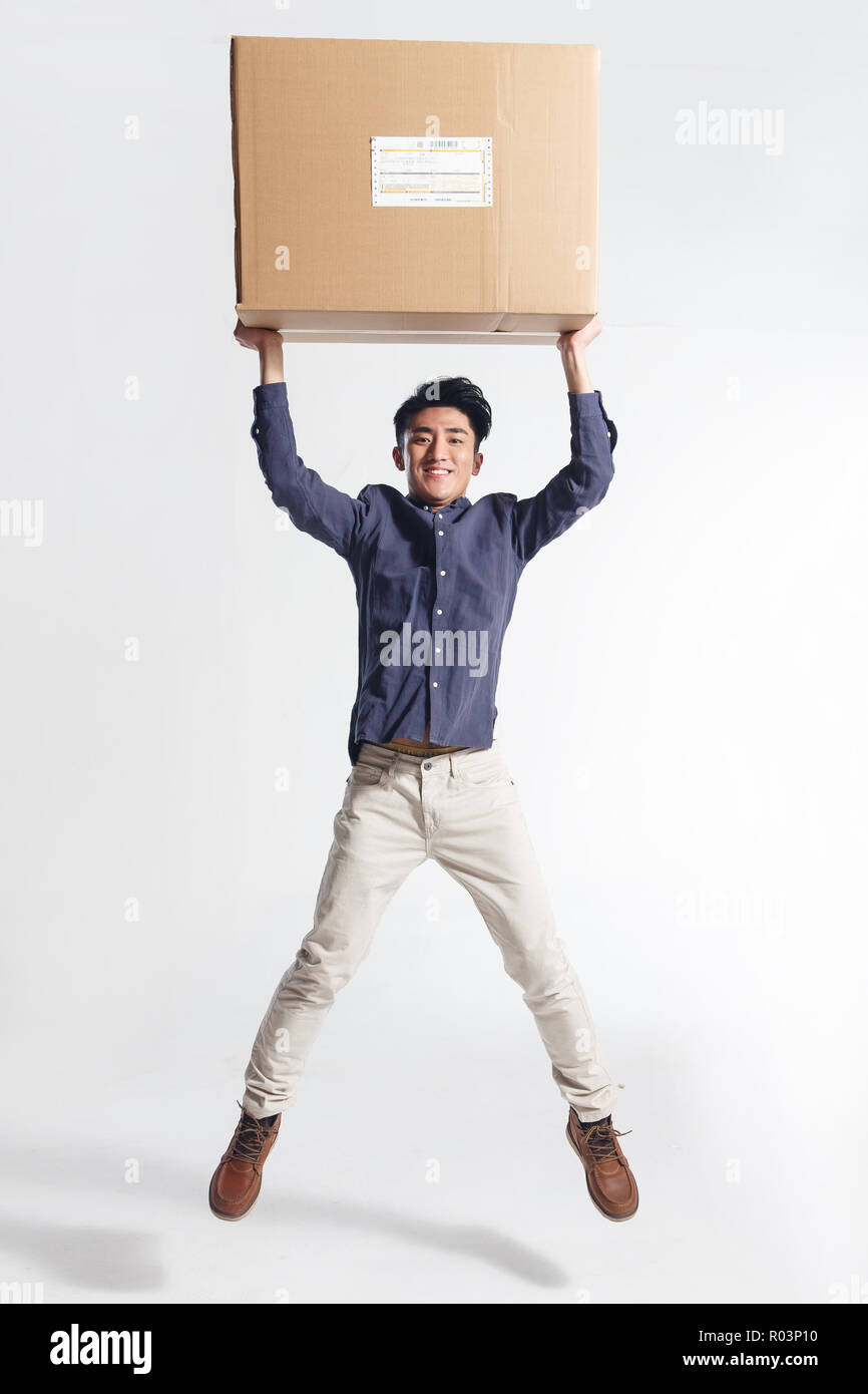 Smiling young delivery man arms hi-res stock photography and images - Alamy