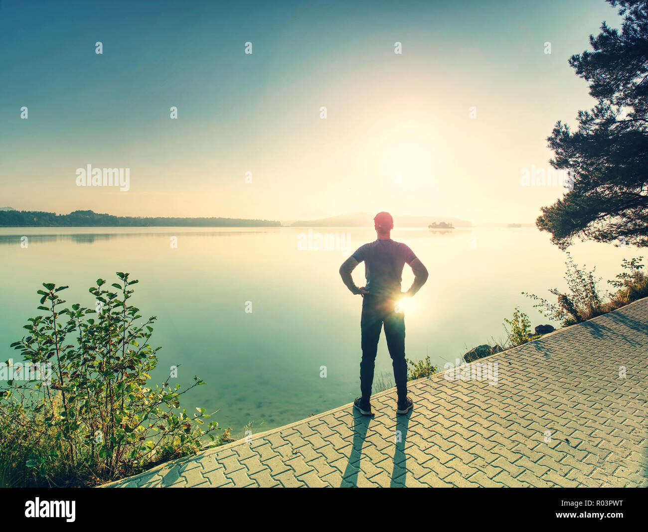 Male runner exercising on footpath at coast of island. Beach at sunset ...