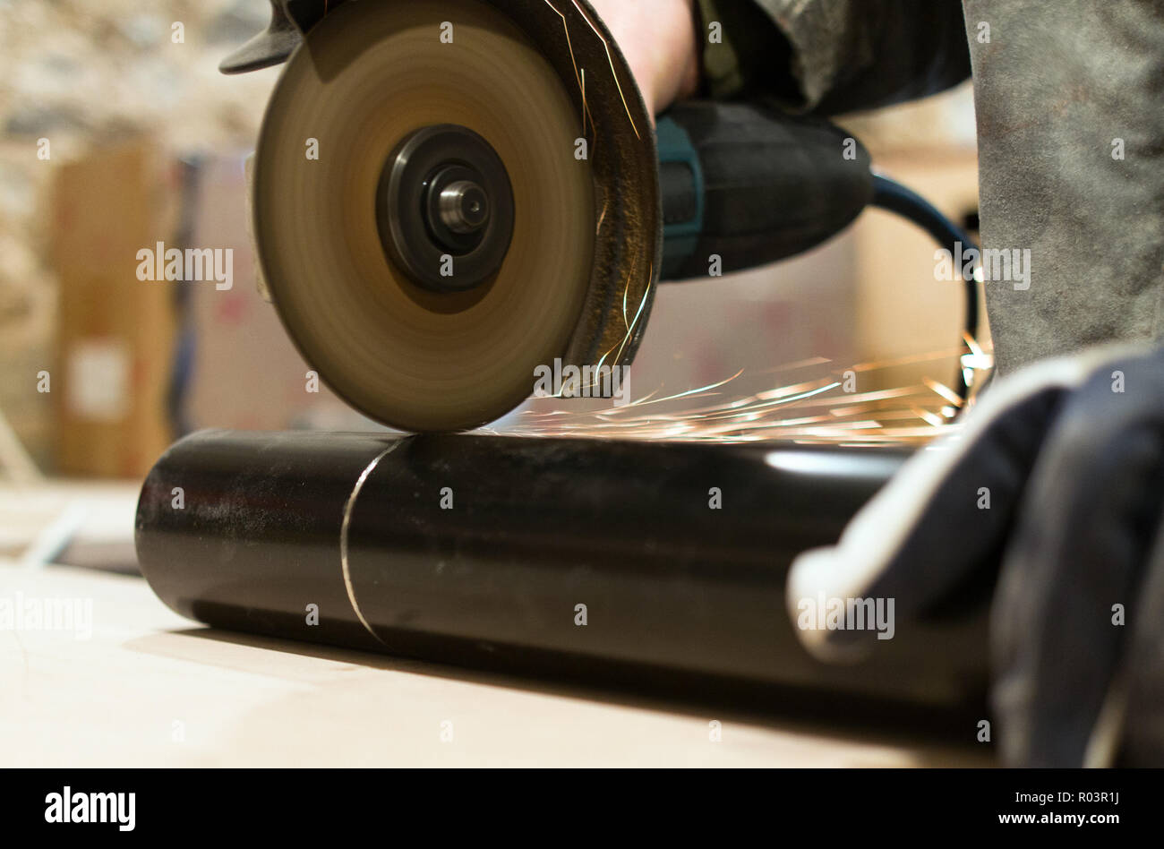 A worker cutting of a metal pipe with an angle grinder Stock Photo - Alamy