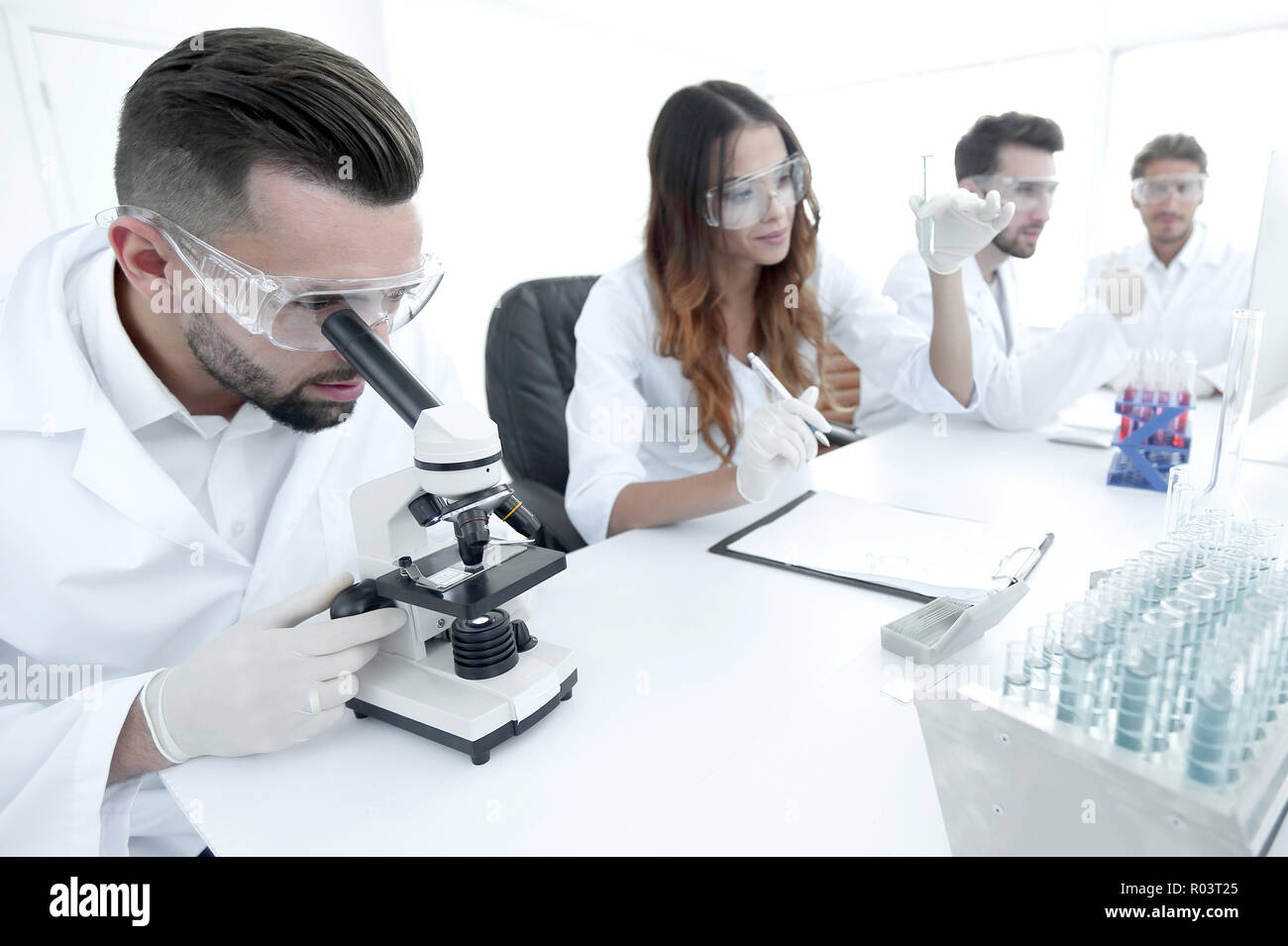 male laboratory technician looking at samples in the microscope Stock ...
