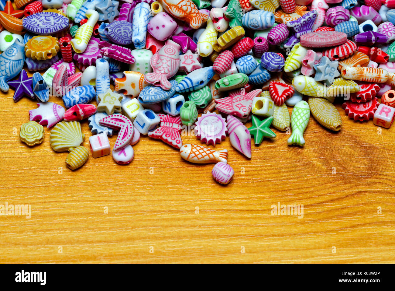 Multi colour beads assortment at wood background Stock Photo - Alamy