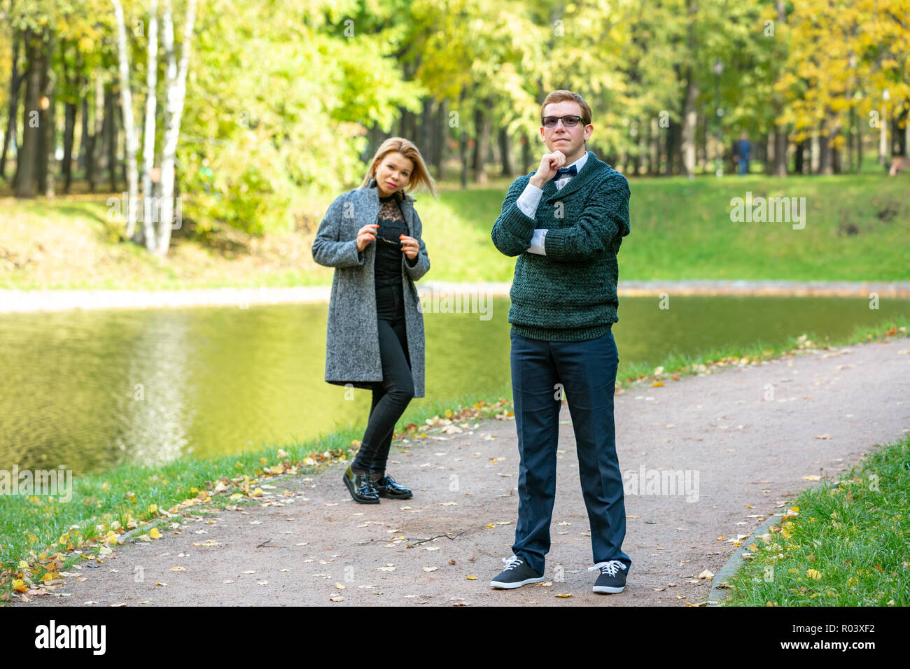 Couple talking seriously outdoors in a park with a green background ...