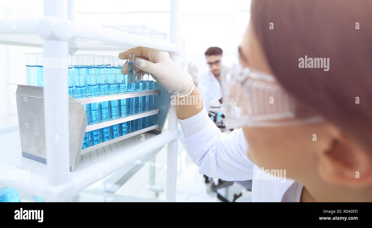 attractive young student scientist observing the blue indicator color ...