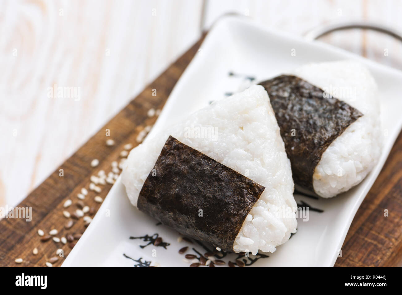 Onigiri. Rice triangle with nori seaweed on white plate Stock Photo - Alamy
