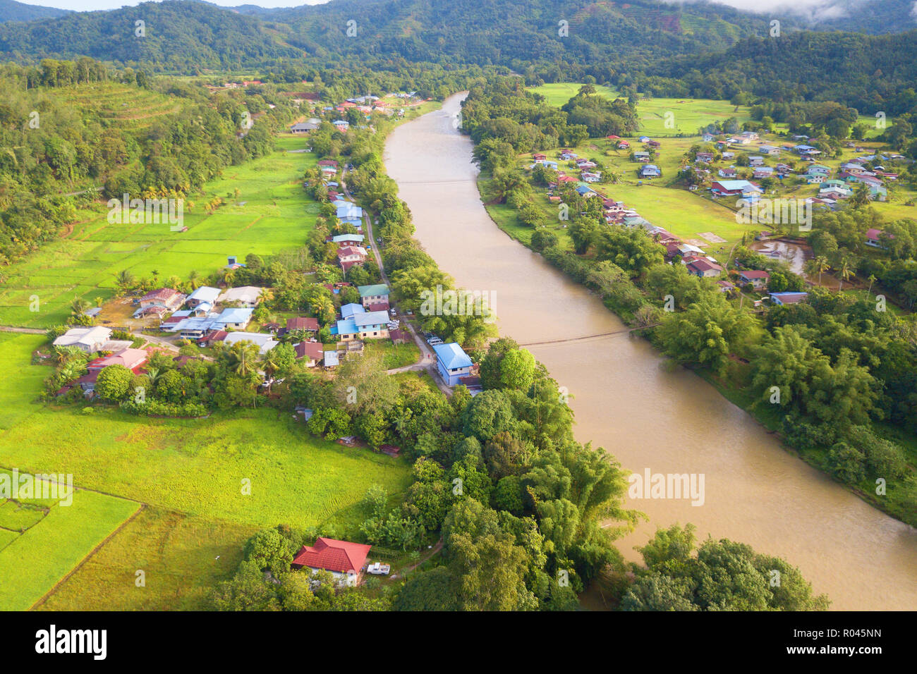 Morning landscape of village with river and green paddy field at Kiulu ...