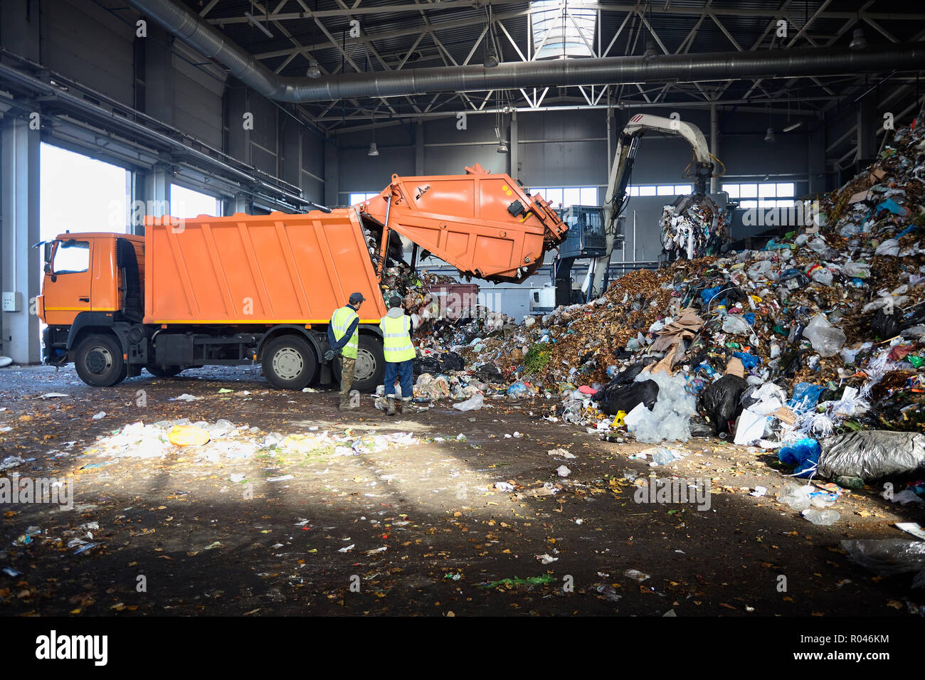Two workers of recycling plant control process of unloading garbage ...