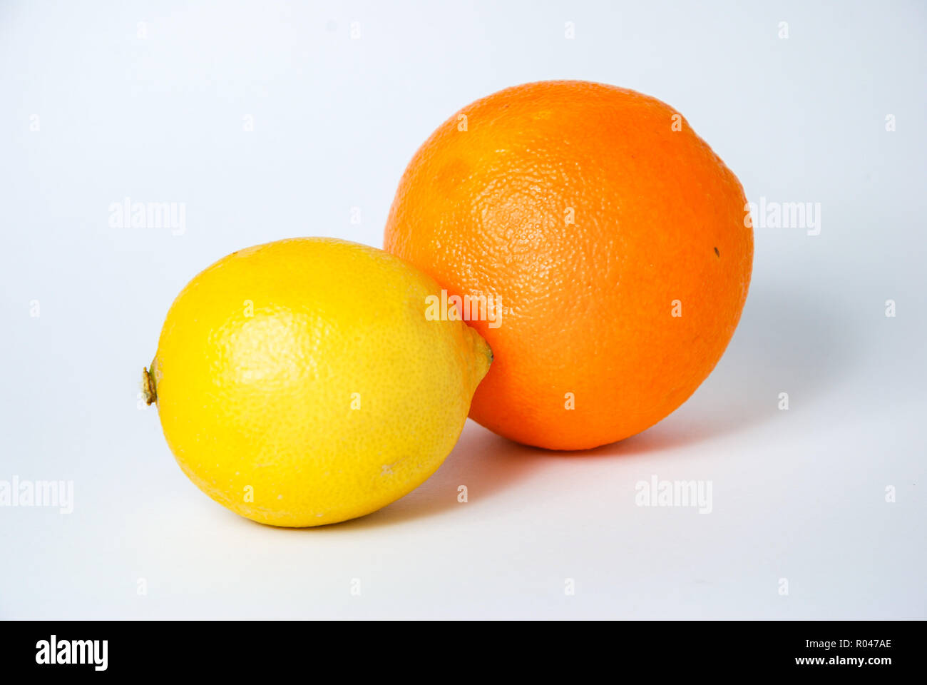 One lemon and one orange on white background Stock Photo - Alamy