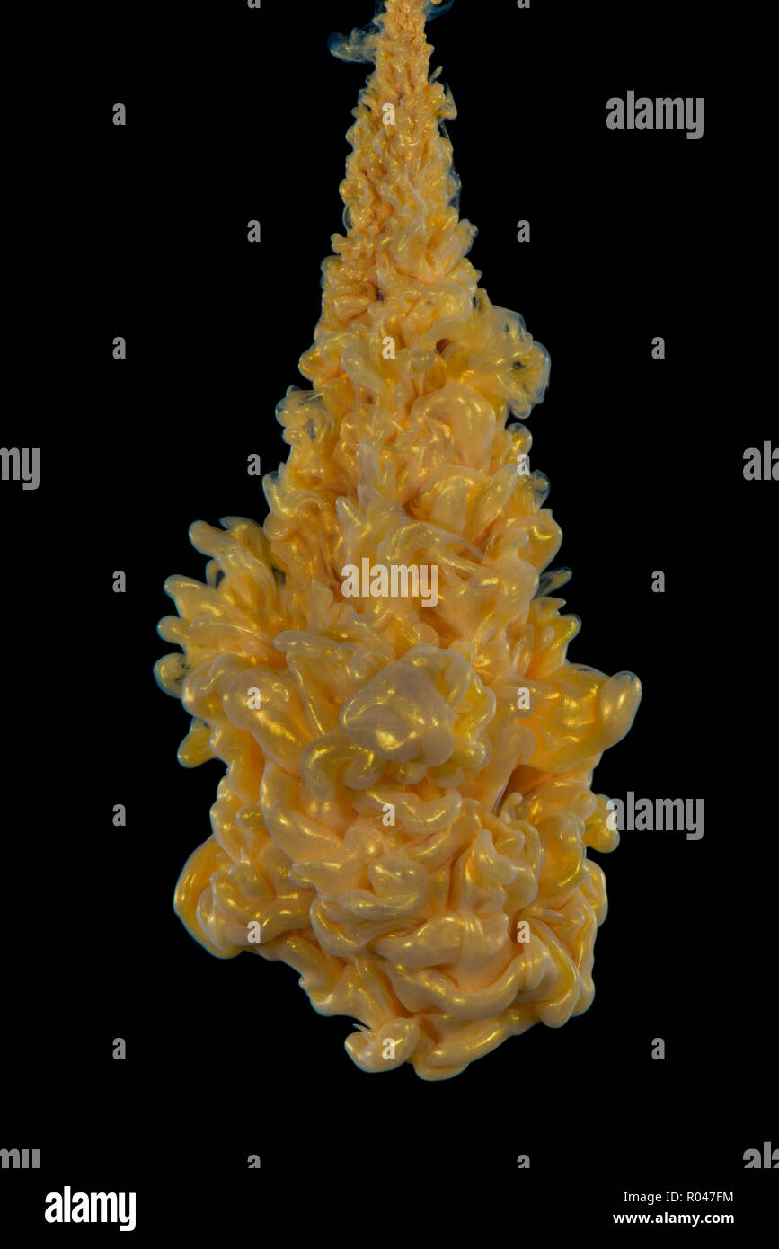 Explosion of golden acrylic paint in water on black background Stock ...