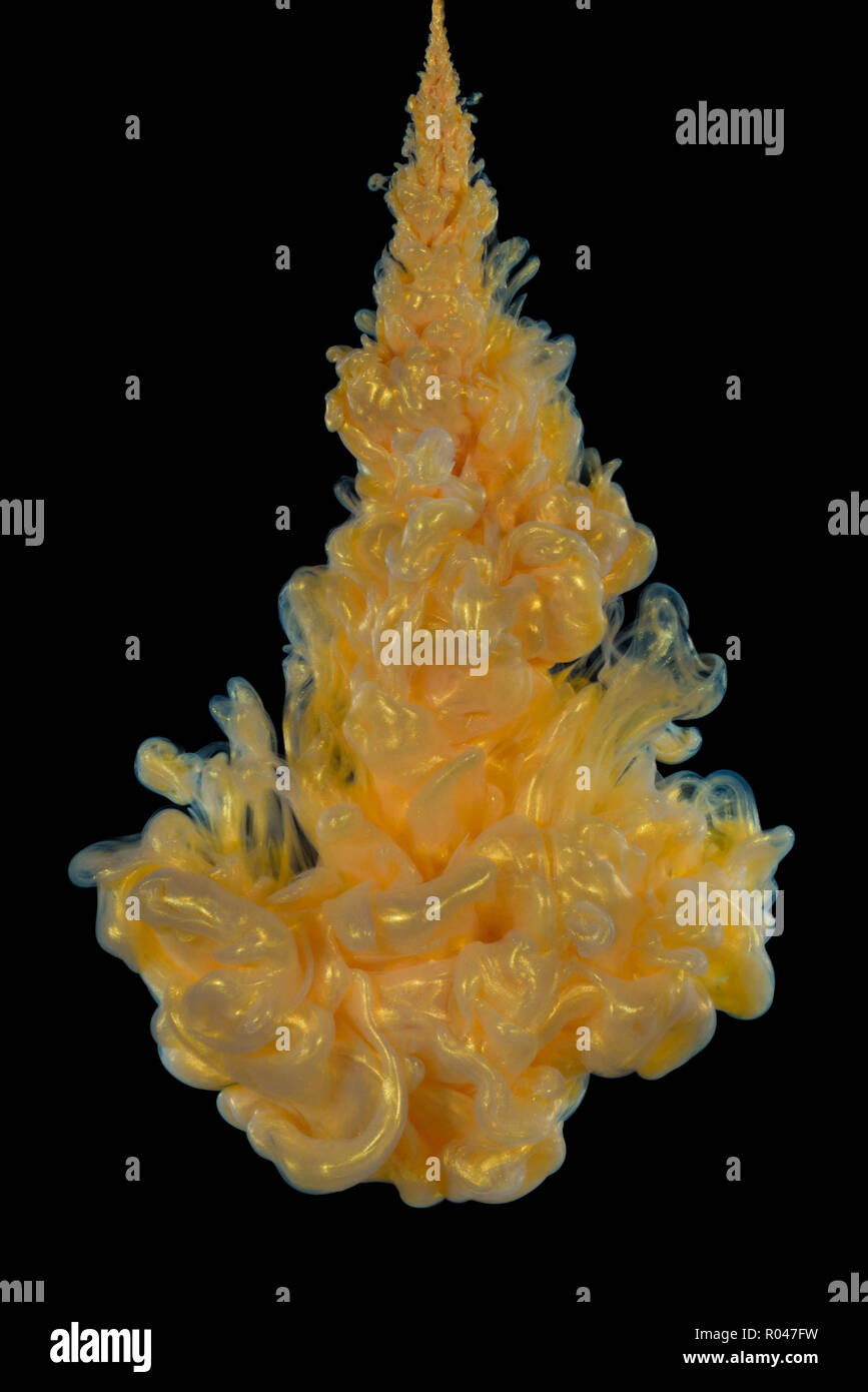 Explosion of golden acrylic paint in water on black background Stock ...
