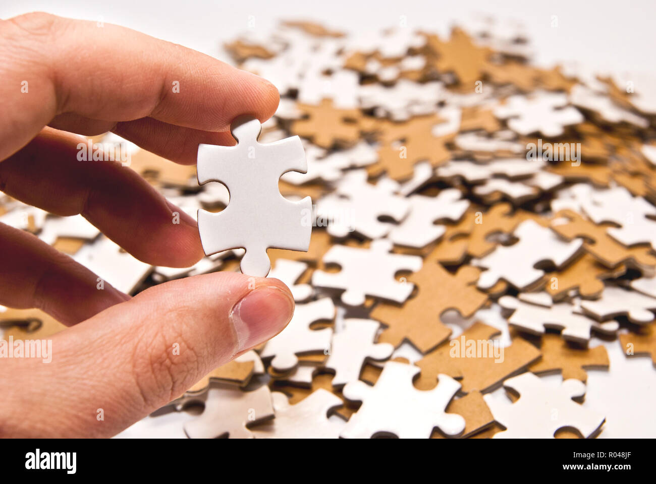 hand holding single puzzle piece Stock Photo - Alamy