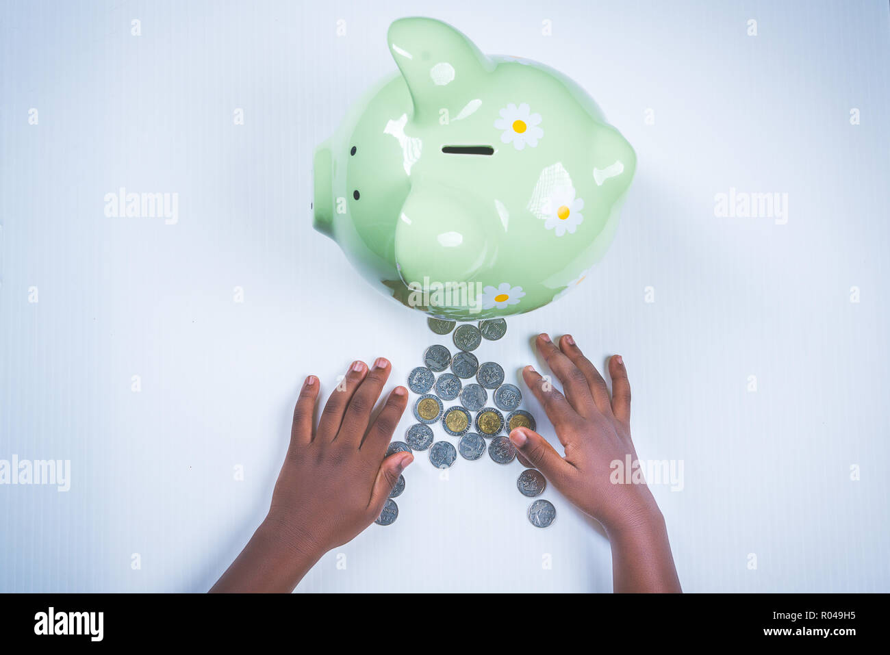 Black girl counting coins by piggy bank Stock Photo - Alamy