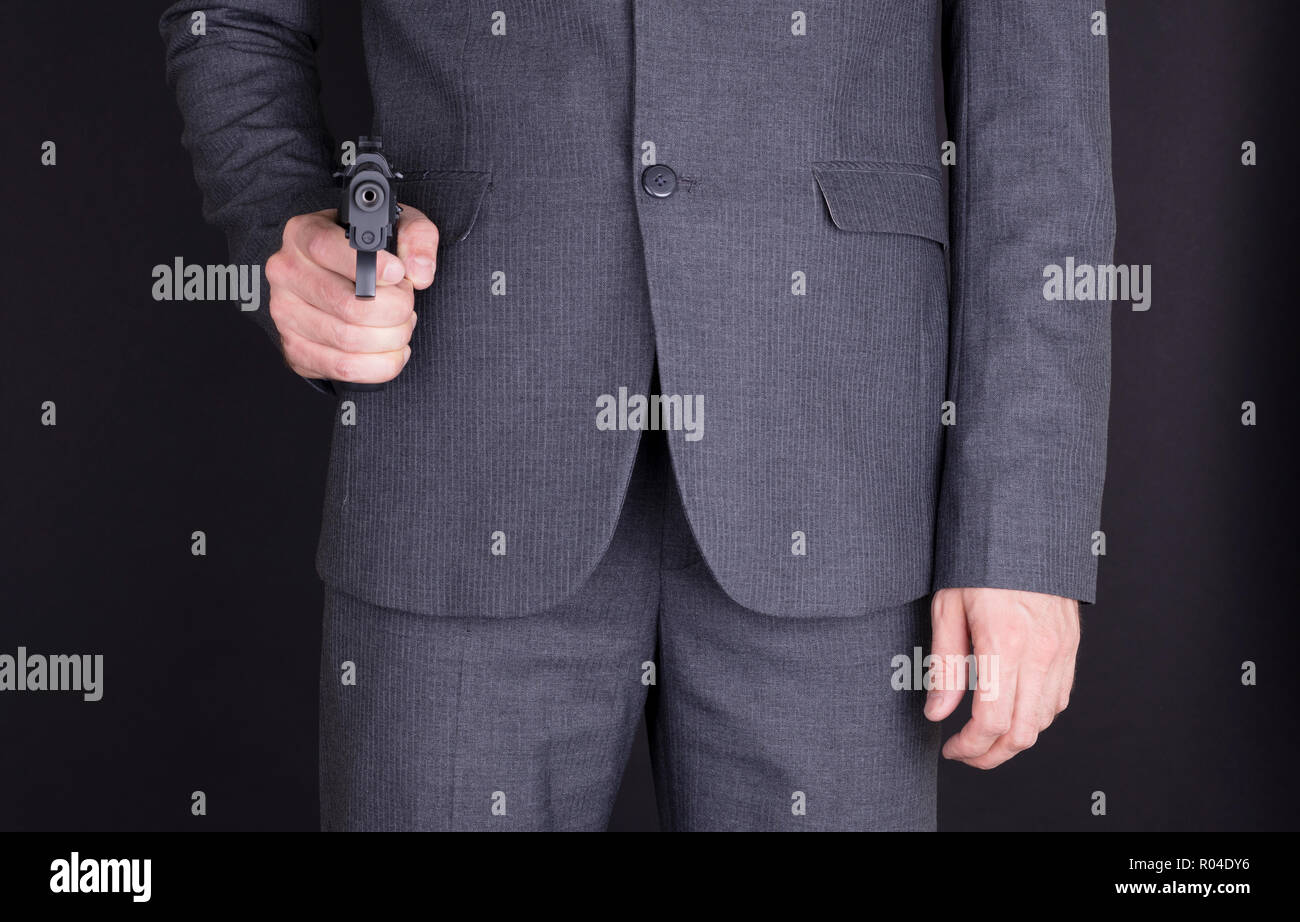 Man in suit with gun, isolated on black Stock Photo - Alamy