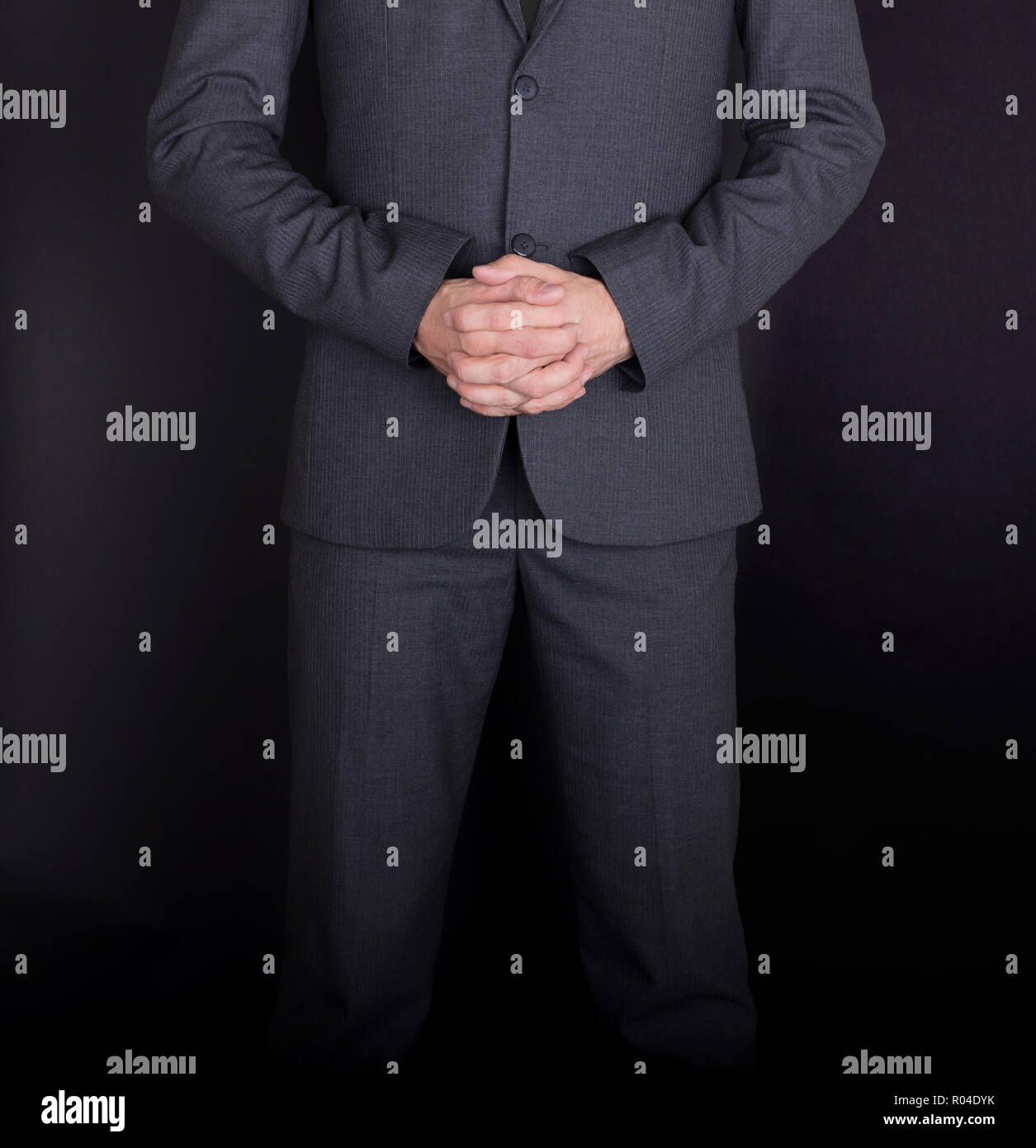 Hands crossed in prayer, man in grey suit Stock Photo - Alamy