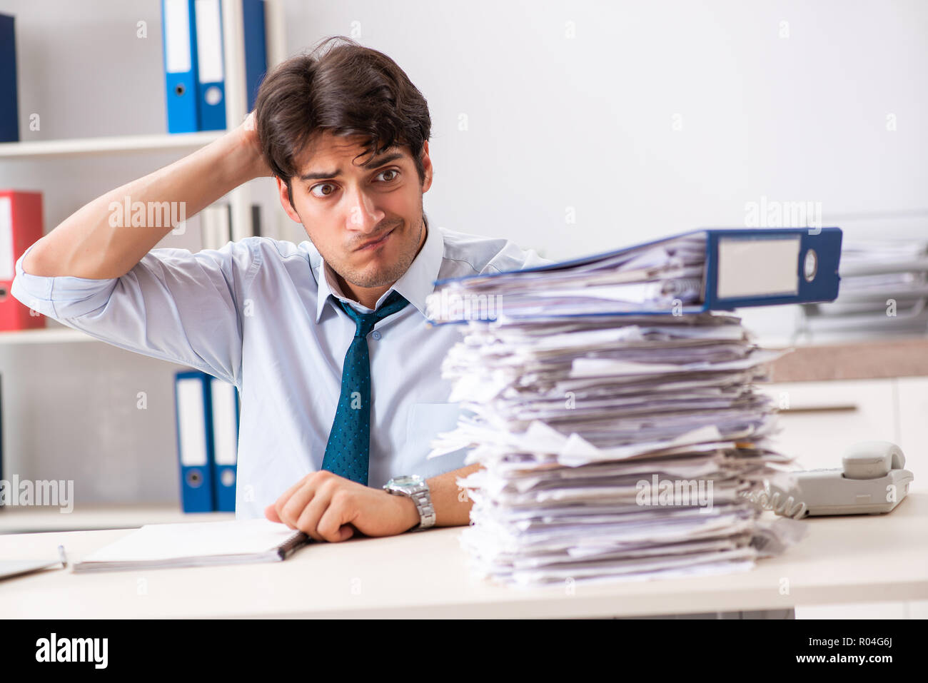 Overloaded busy employee with too much work and paperwork Stock Photo ...