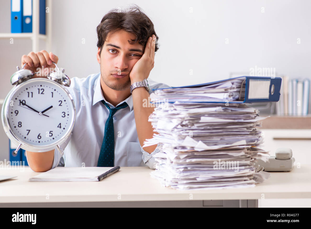 Overloaded busy employee with too much work and paperwork Stock Photo ...