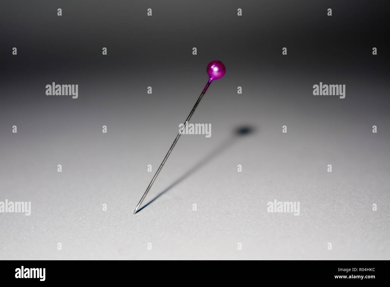 purple pin sticked in white background Stock Photo - Alamy