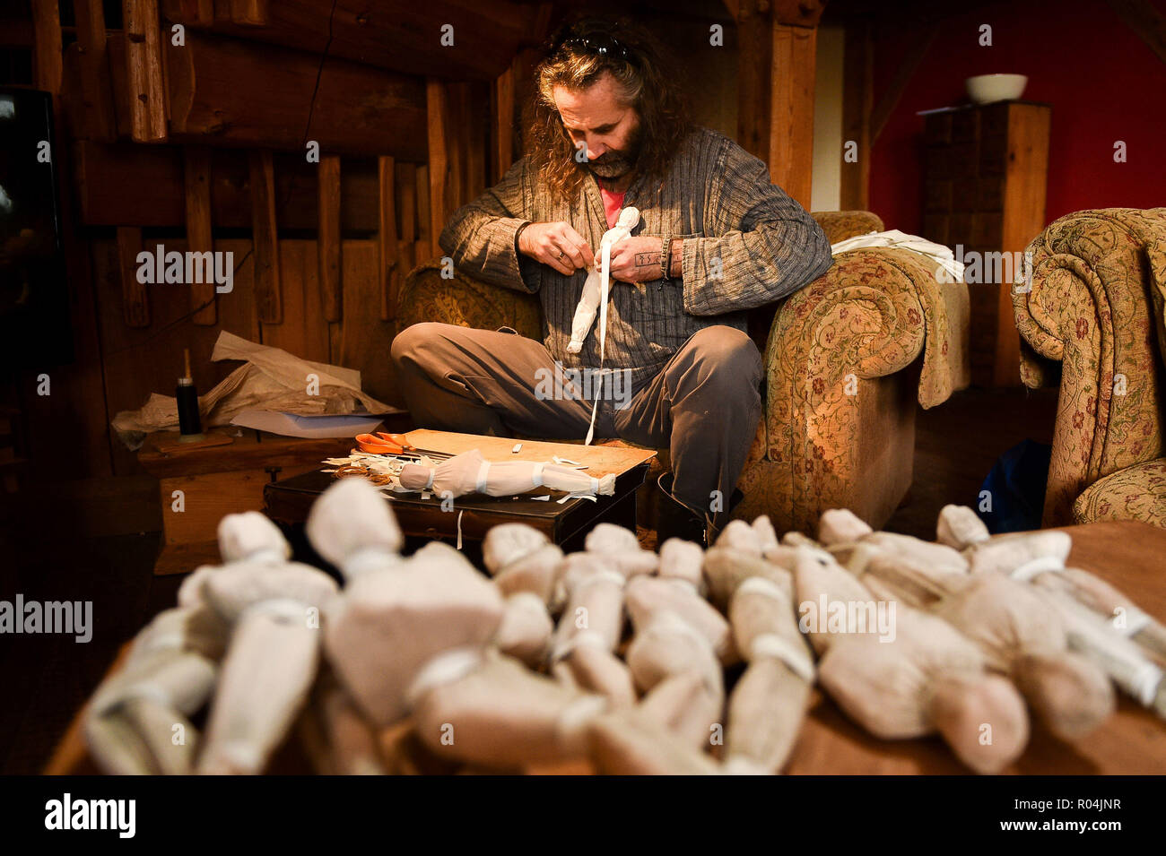 Artist Rob Heard ties ribbon around a shrouded figure at his Somerset ...