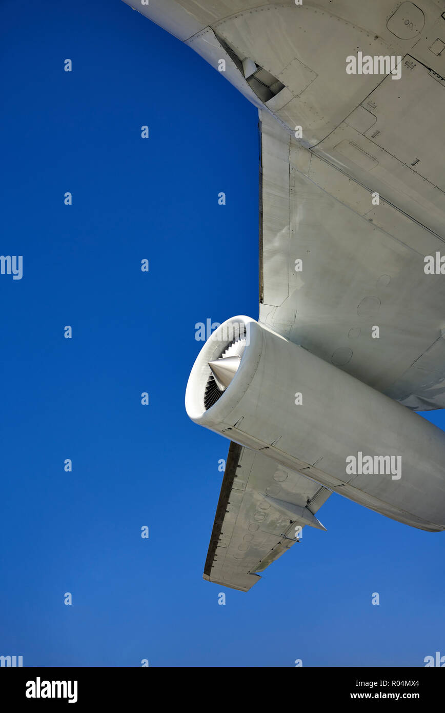 Airplane engine and wing detail against a deep blue sky. Aircraft in ...