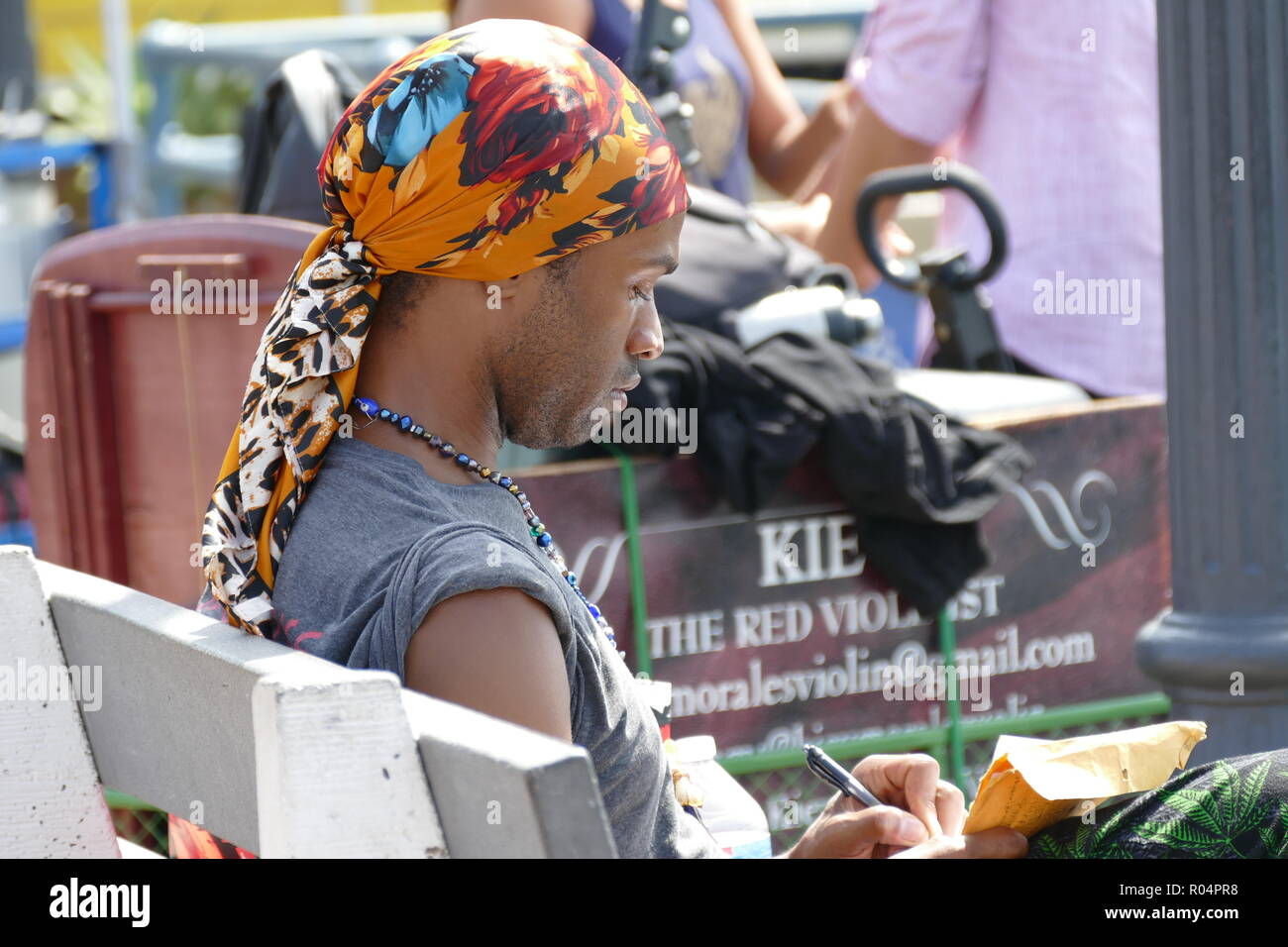 man sitting on bench writing Stock Photo - Alamy