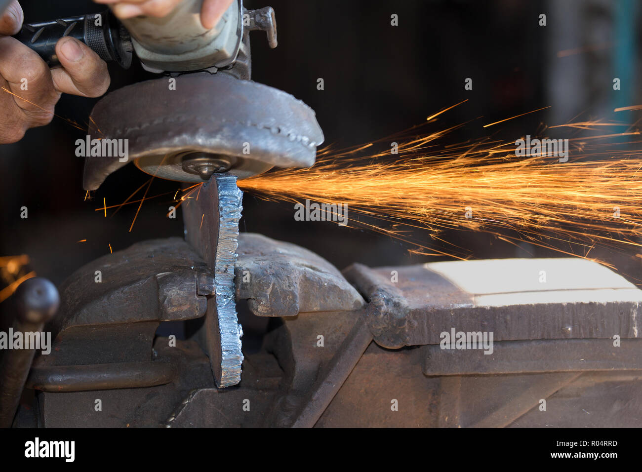 Thai worker grinding a metal part in his workshop Stock Photo - Alamy