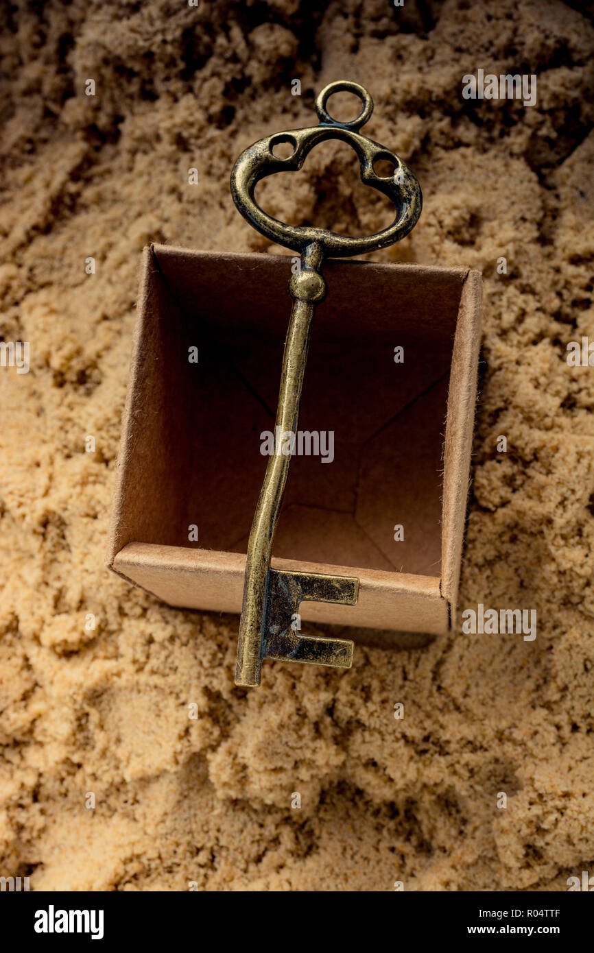 Retro style key placed in a brown box on sand Stock Photo - Alamy