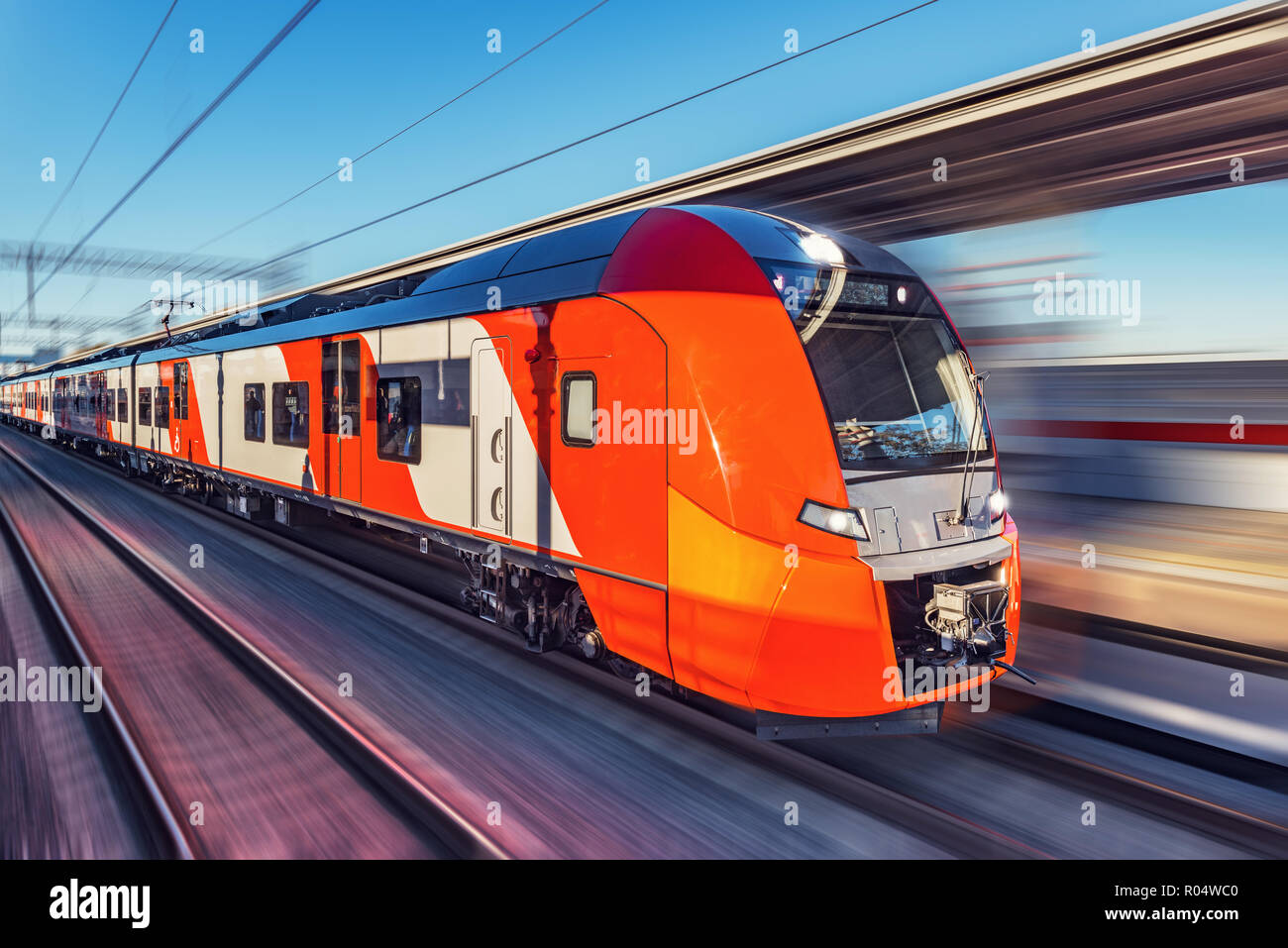Modern high-speed train moves fast along the platform Stock Photo - Alamy
