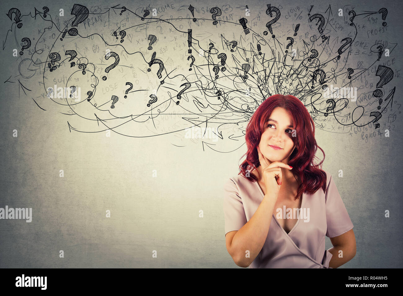 Young redhead pensive woman having questions holding hand under chin ...