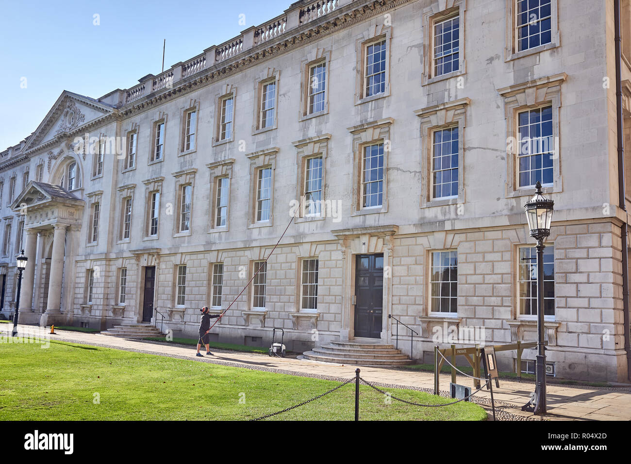 Window cleaner with long pole works on the windows of the Gibb's ...