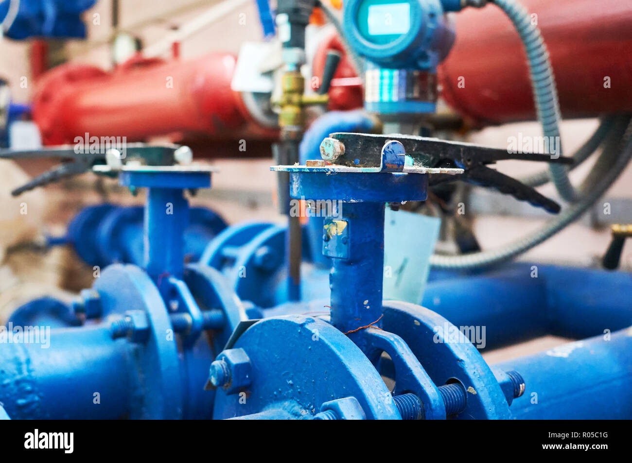 Gate valves installed on pipes painted in blue. Industrial background ...