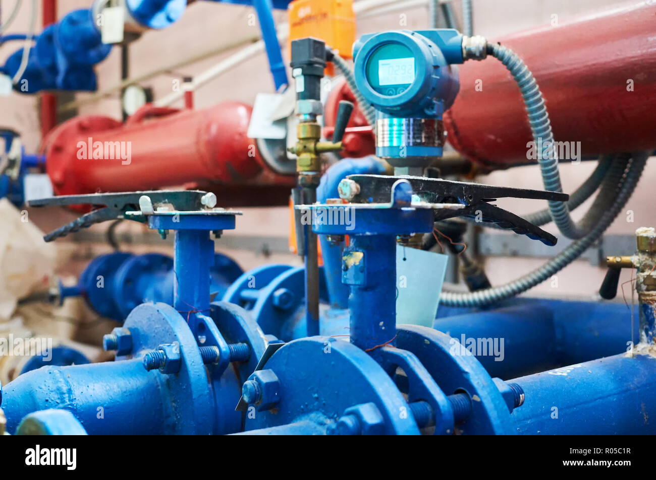 Gate valves installed on pipes painted in blue. Industrial background ...