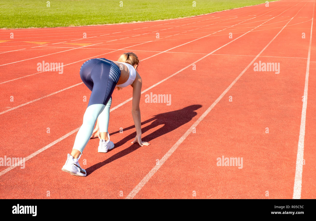 Beautiful woman ready to start running on runway Stock Photo - Alamy