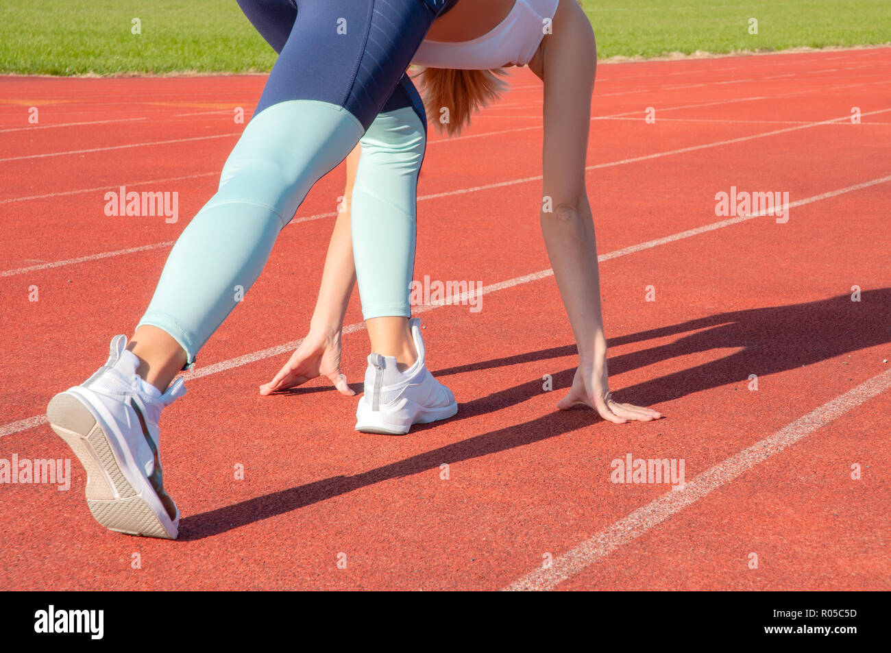 Beautiful woman ready to start running on runway Stock Photo - Alamy