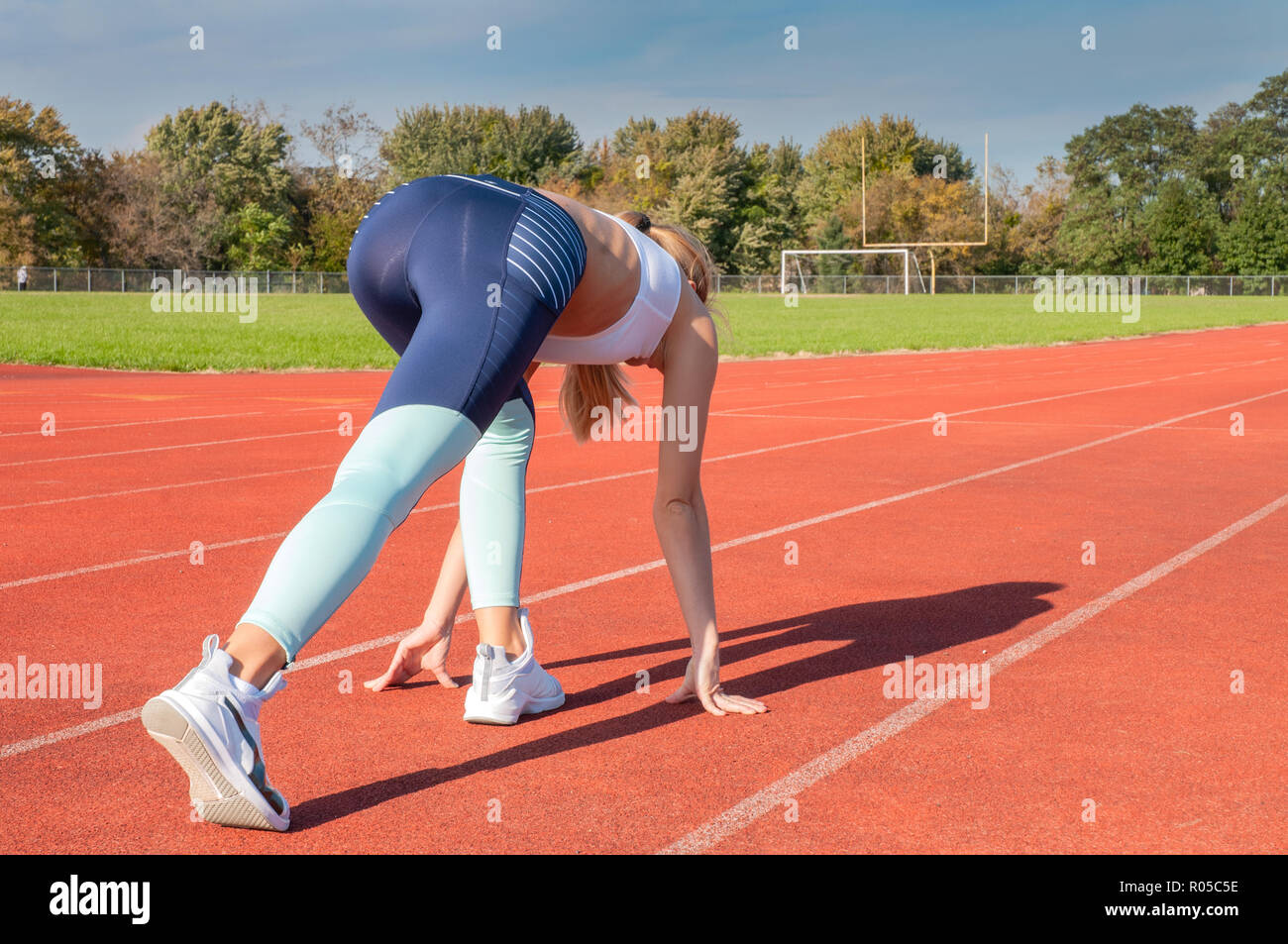 Beautiful woman ready to start running on runway Stock Photo - Alamy