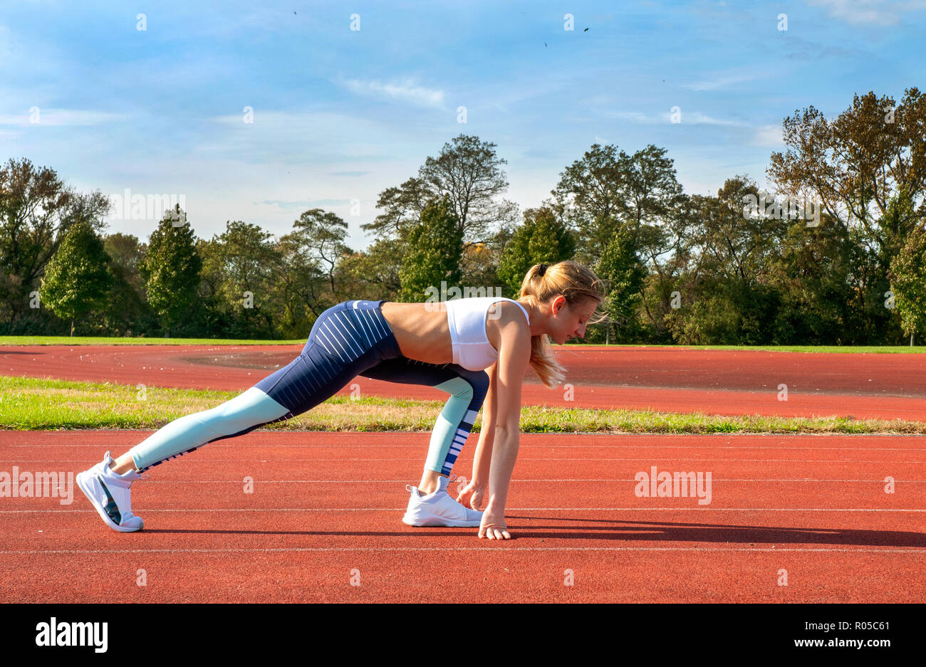 Beautiful woman ready to start running on runway Stock Photo - Alamy