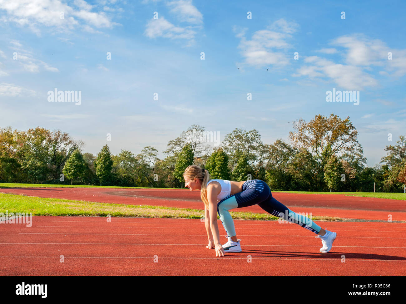 Beautiful woman ready to start running on runway Stock Photo - Alamy